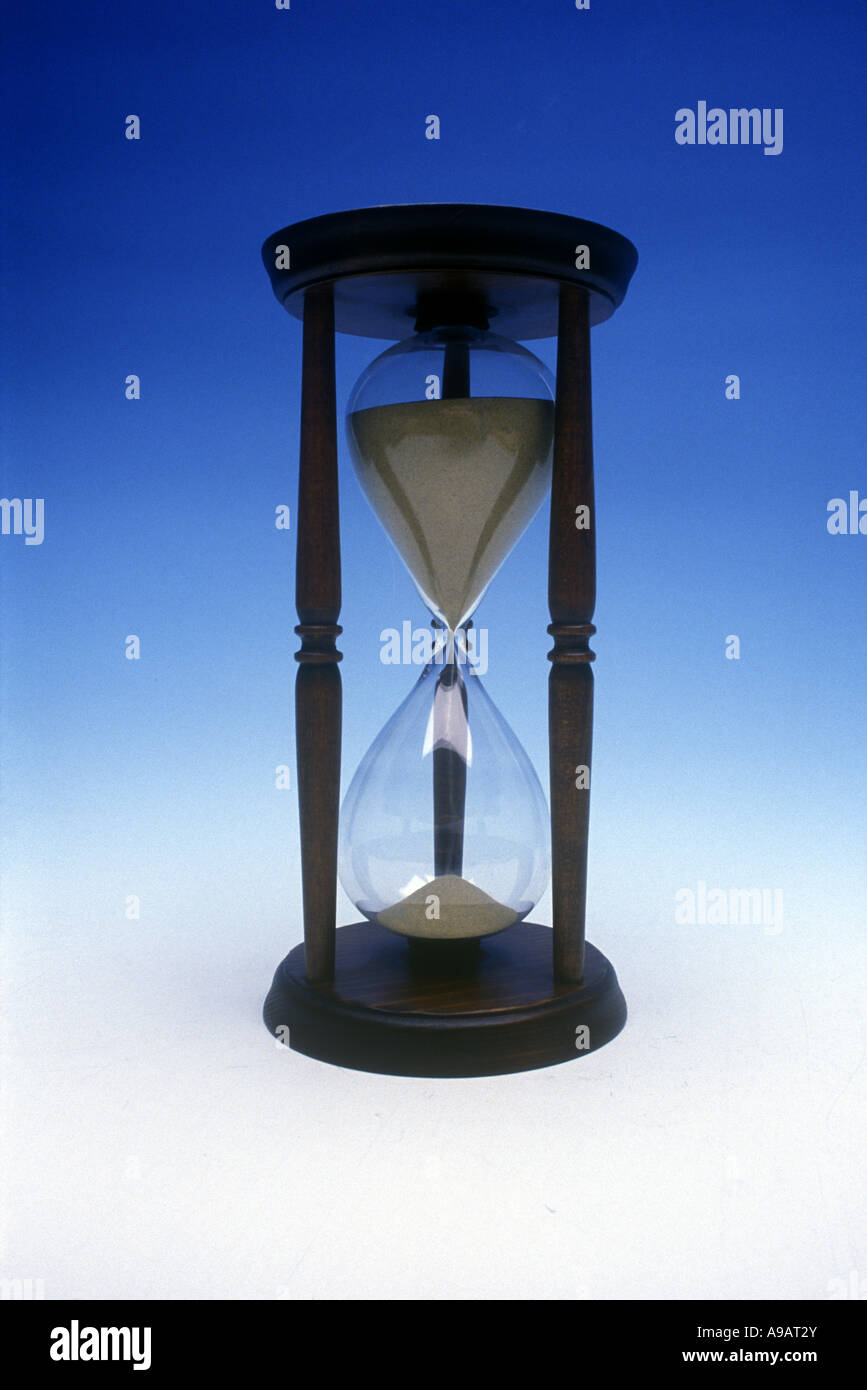 SAND FALLING THROUGH OLD FASHIONED HOURGLASS SAND TIMER Stock Photo - Alamy