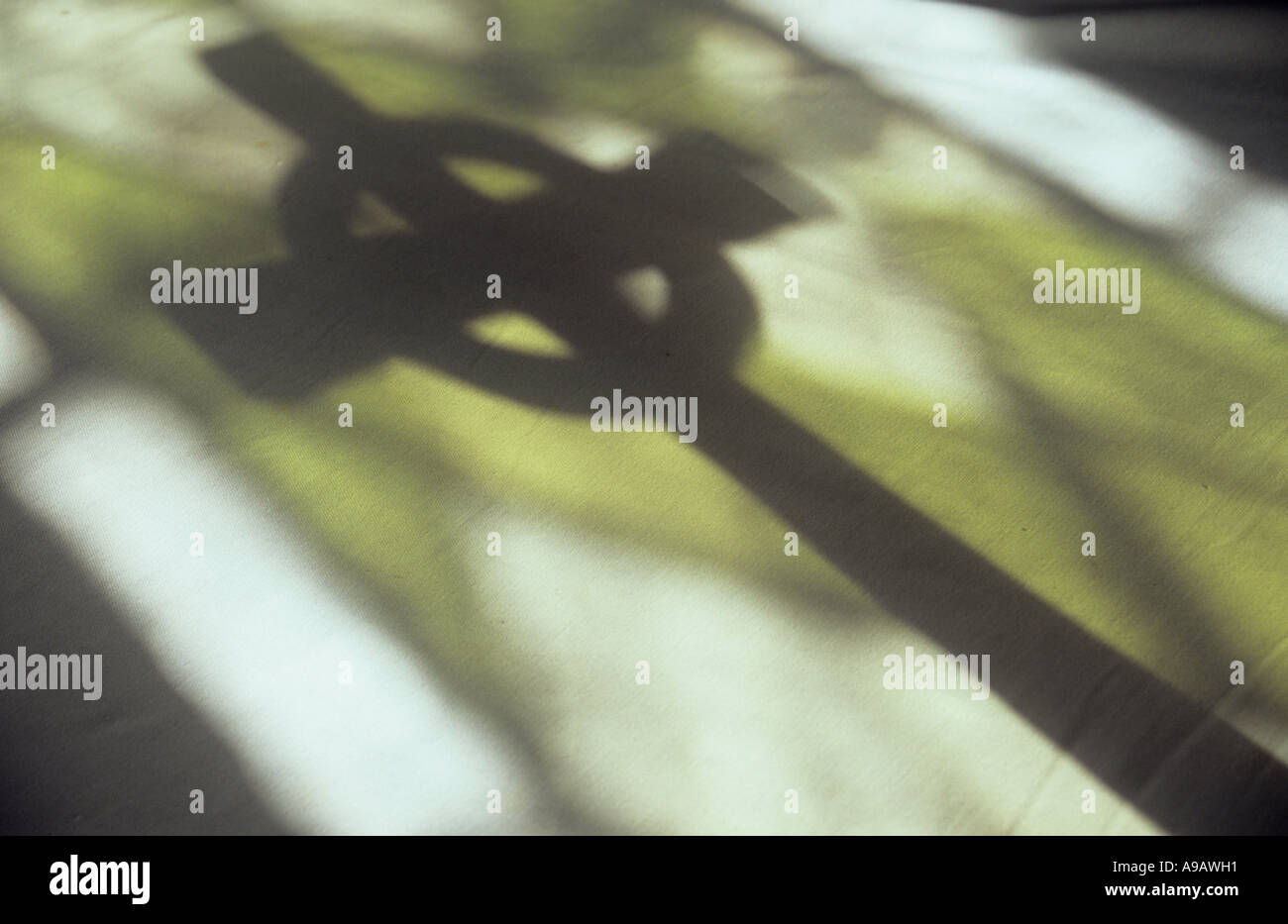 Shadow of a Celtic cross crucifix cast onto a pale background with the ...