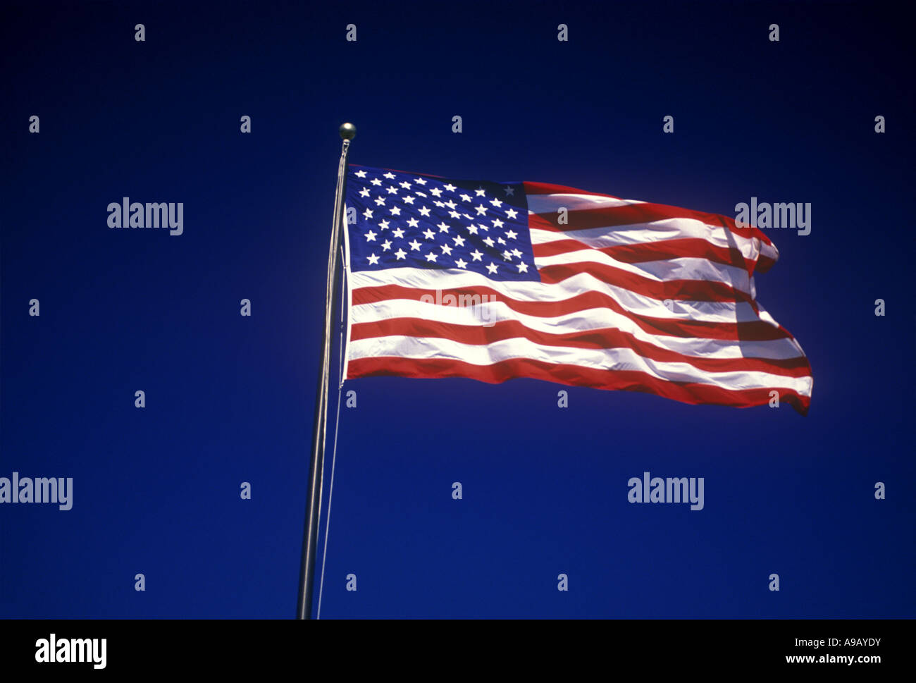 FULL UNITED STATES OF AMERICA FLAG FLYING ON FLAGPOLE WITH CLEAR BLUE ...