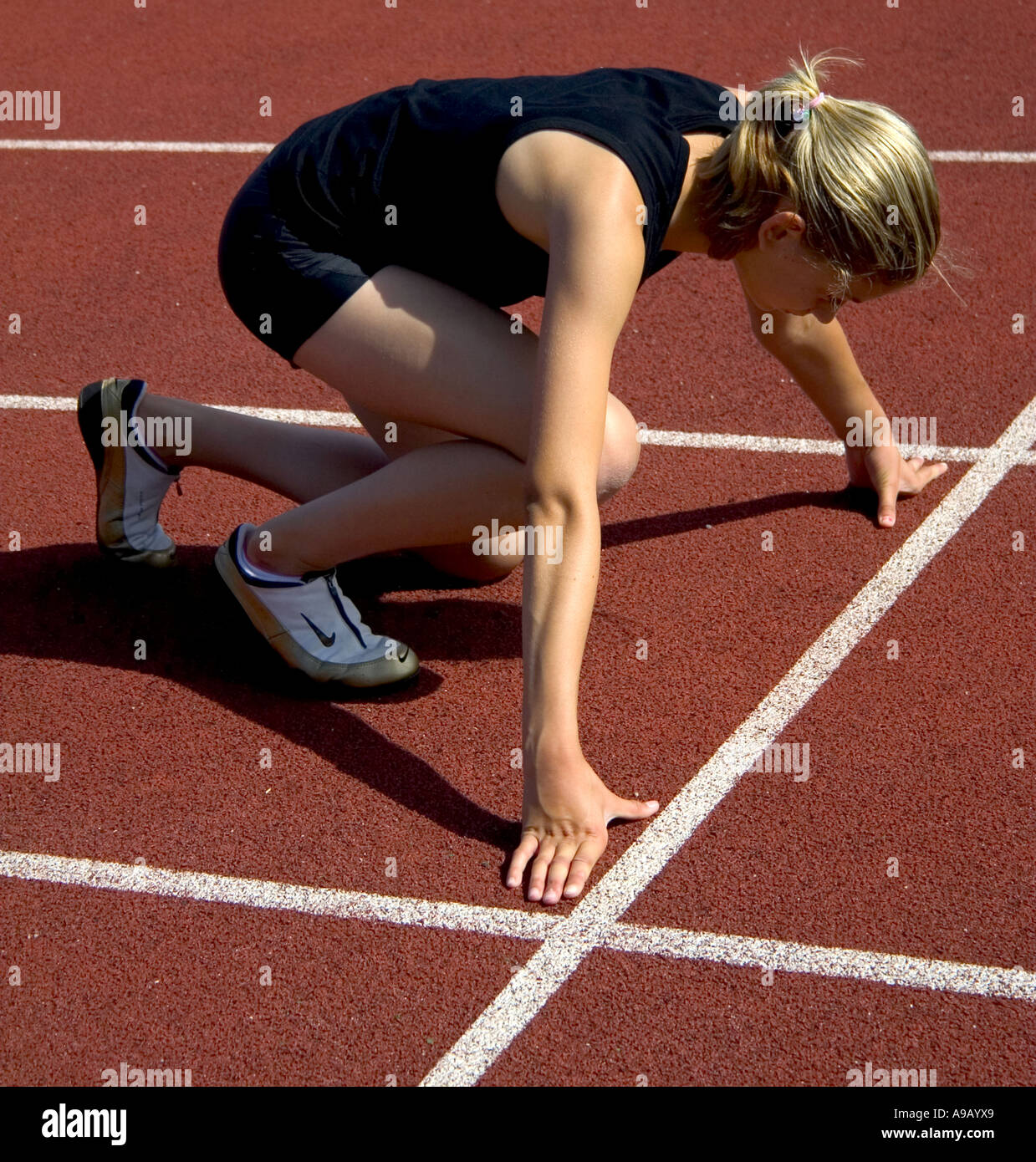 Teenage female athlete on starting line Stock Photo - Alamy