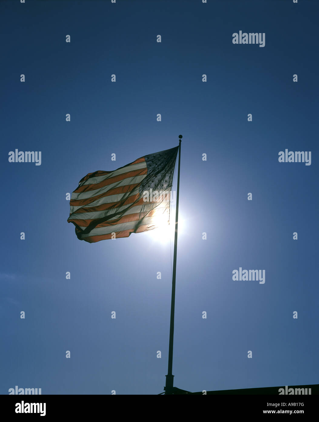 UNITED STATES FLAG FLYING ON FLAGPOLE WITH BLUE SKY Stock Photo - Alamy