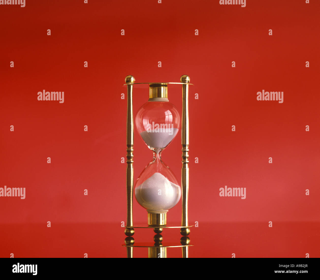 SAND FALLING THROUGH OLD FASHIONED BRASS HOURGLASS SAND TIMER ON RED ...