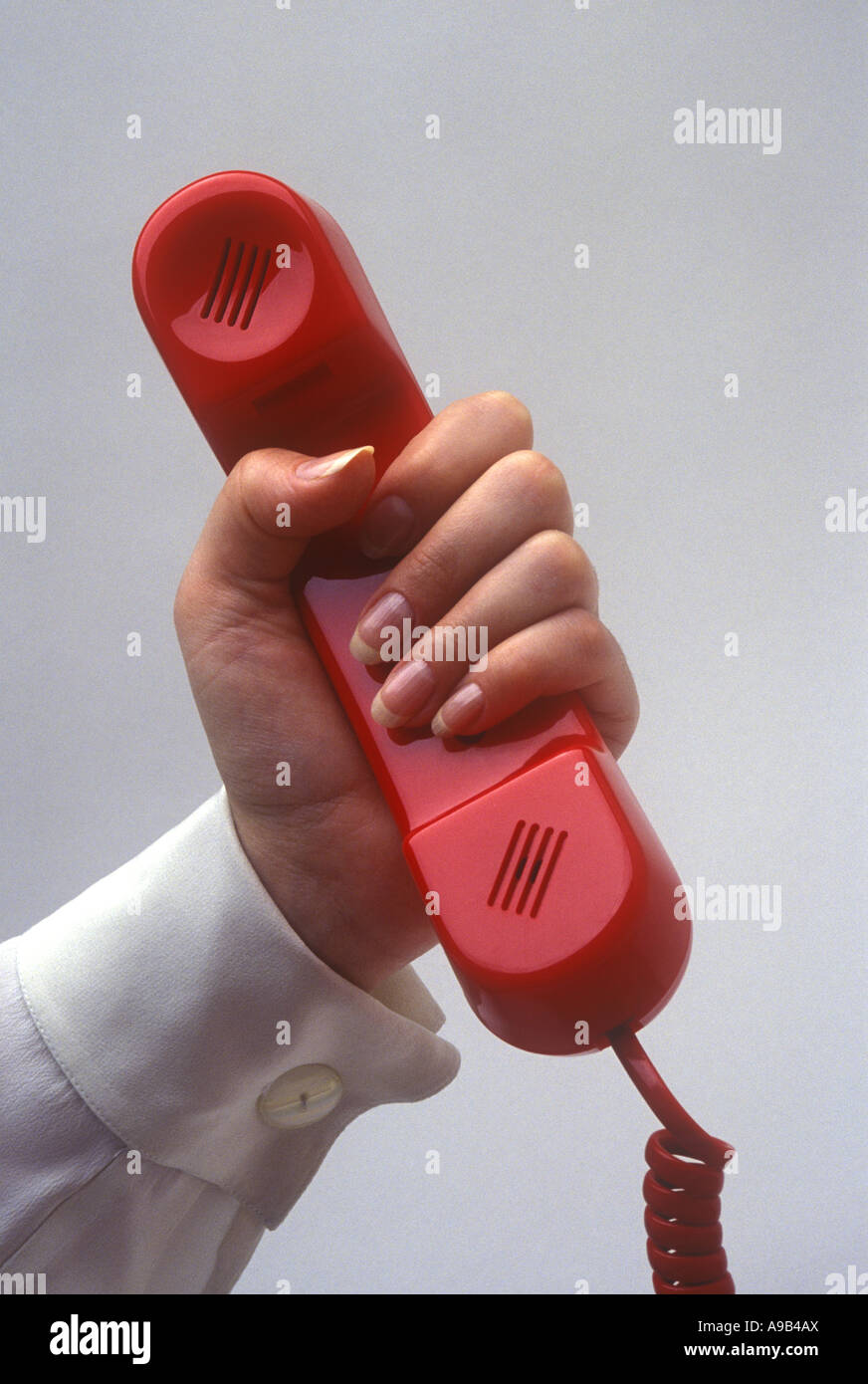 WOMANS HAND HOLDING RED TELEPHONE HANDSET Stock Photo - Alamy