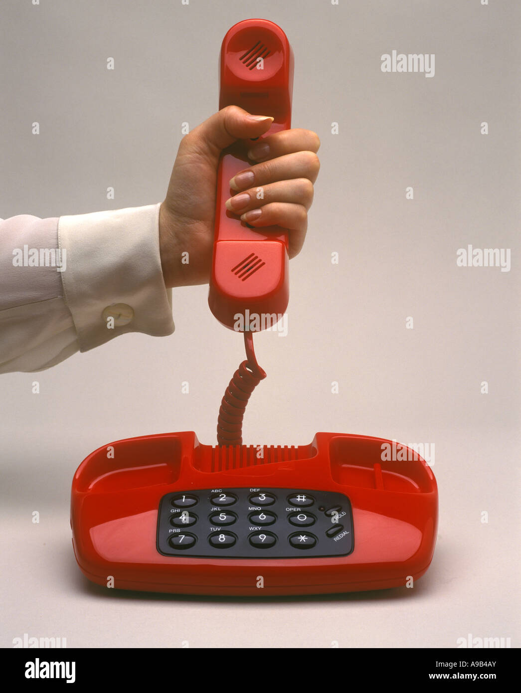 WOMANS HAND HOLDING RED TELEPHONE HANDSET Stock Photo - Alamy