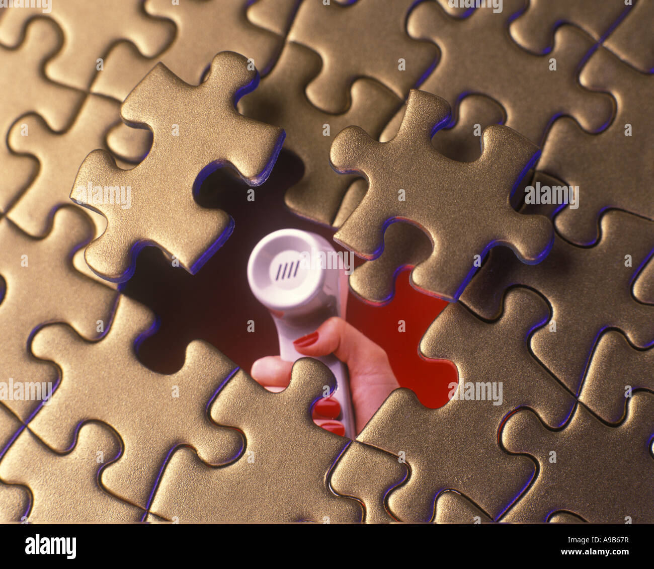 GOLDEN JIGSAW PUZZLE WITH TWO PIECES OPEN TO TELEPHONE HANDSET Stock ...