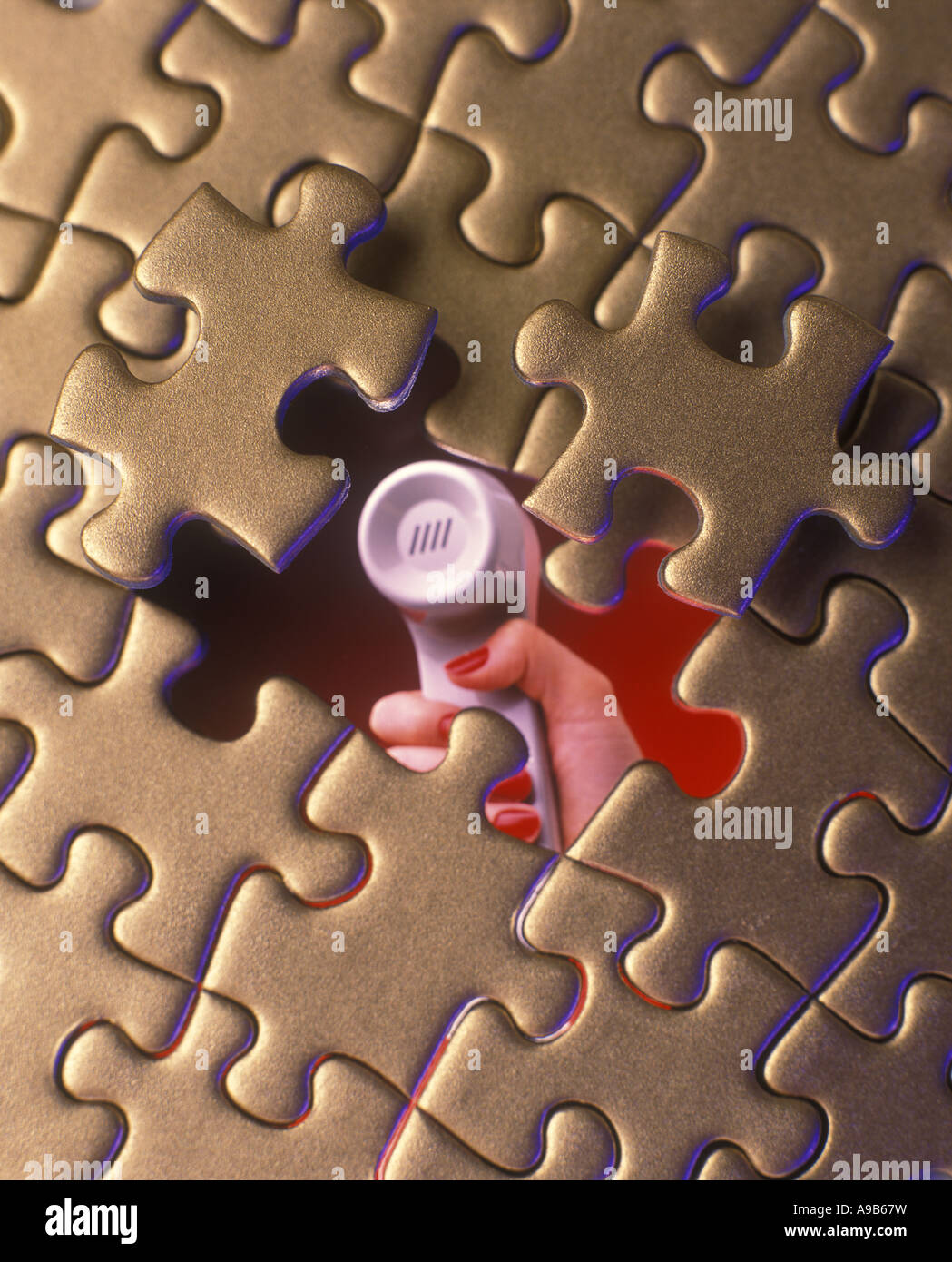 GOLDEN JIGSAW PUZZLE WITH TWO PIECES OPEN TO TELEPHONE HANDSET Stock ...