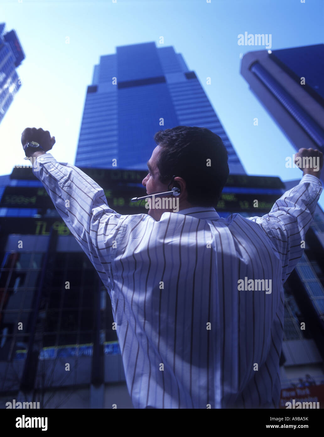 HAPPY SMILING OFFICE WORKER LOOKING UP STANDING WITH ARMS RAISED BY ...