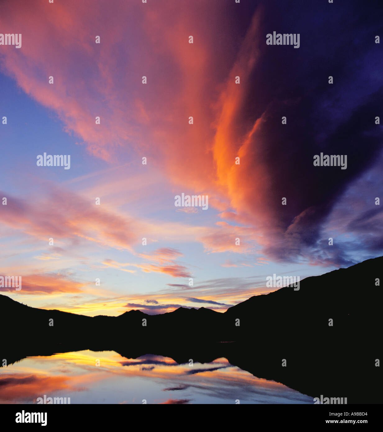 Dramatic sunset behind Yr Wyddfa (Snowdon) seen over Lynnau Mymbr, near ...