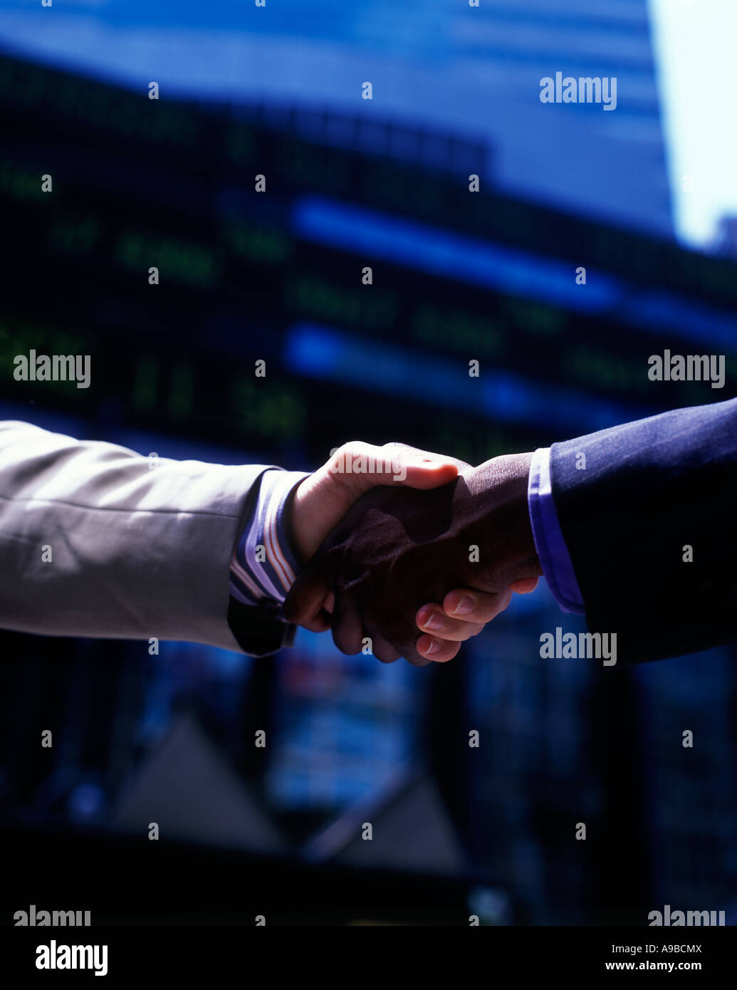 OFFICE WORKERS HANDSHAKE BY STOCK MARKET TICKER DISPLAY Stock Photo - Alamy