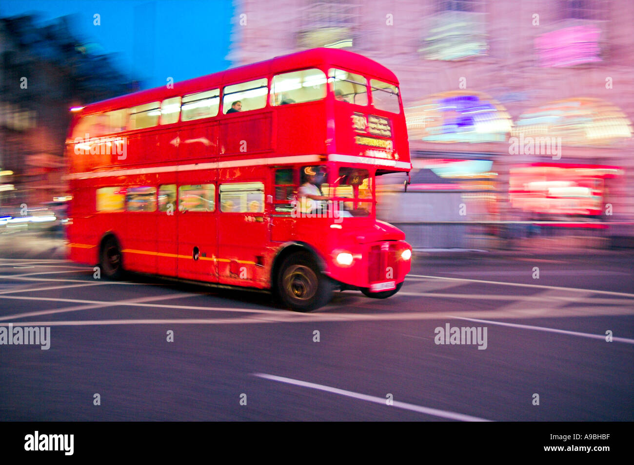 Blur of a red double decker routemaster bus at night in London England ...