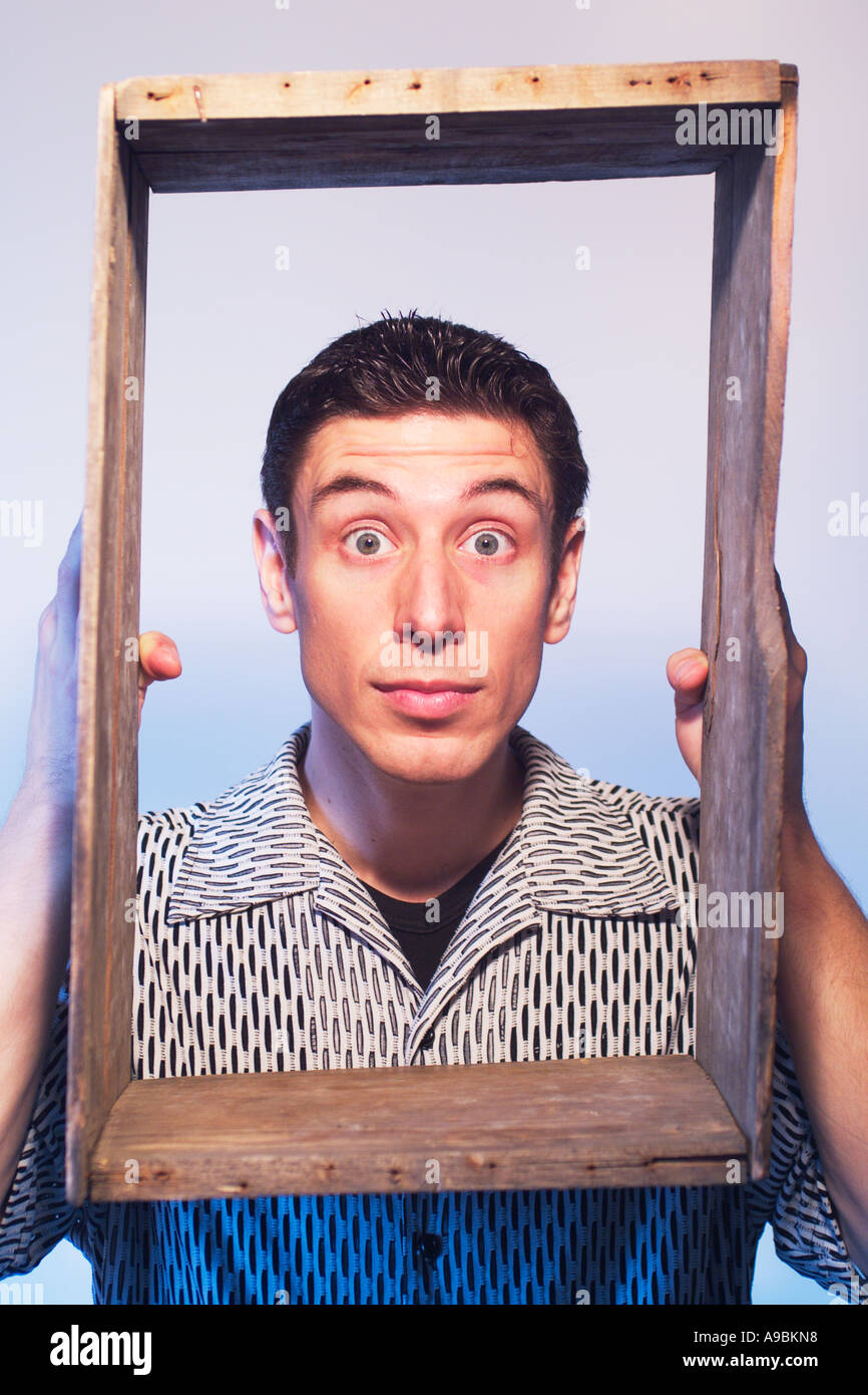Man looking through wooden box frame Stock Photo - Alamy