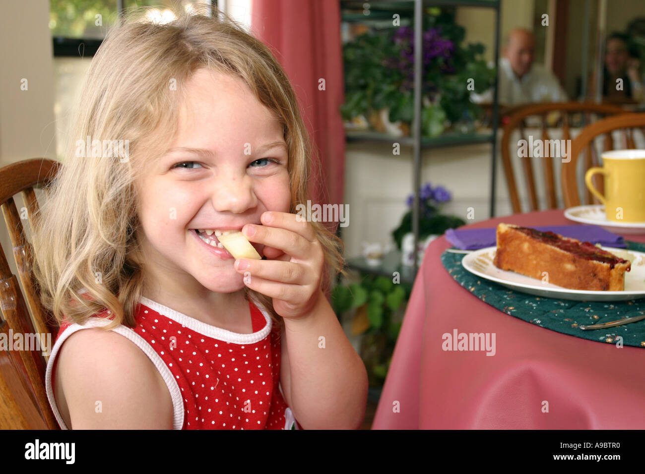 young blond haired girl eating fresh fruit Stock Photo - Alamy