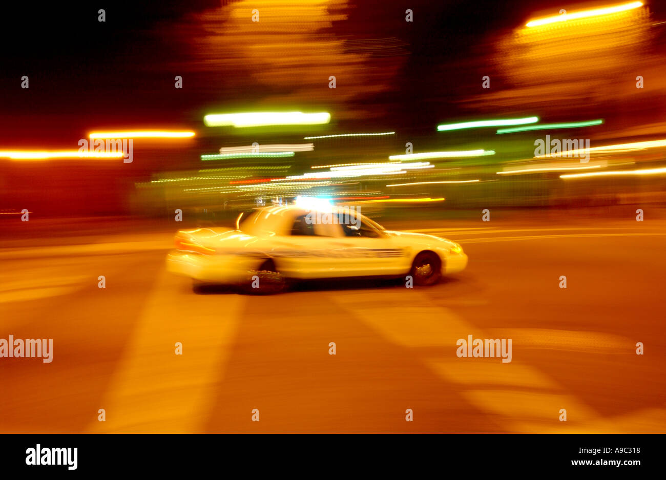 Horizontal color image of city police car traveling fast on city street ...
