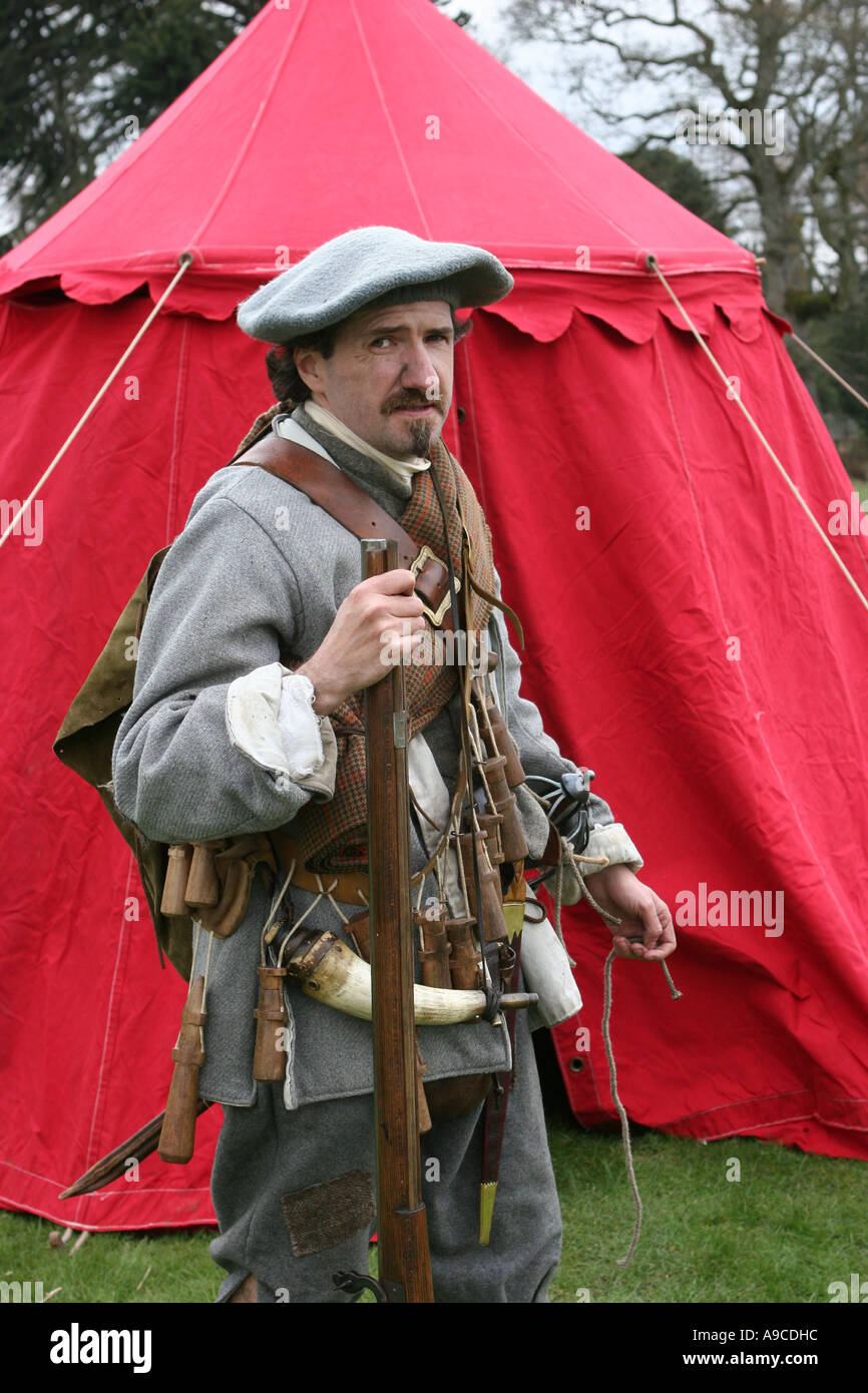 Armed Musketeer reenactor ressed in colourful historical period costume ...