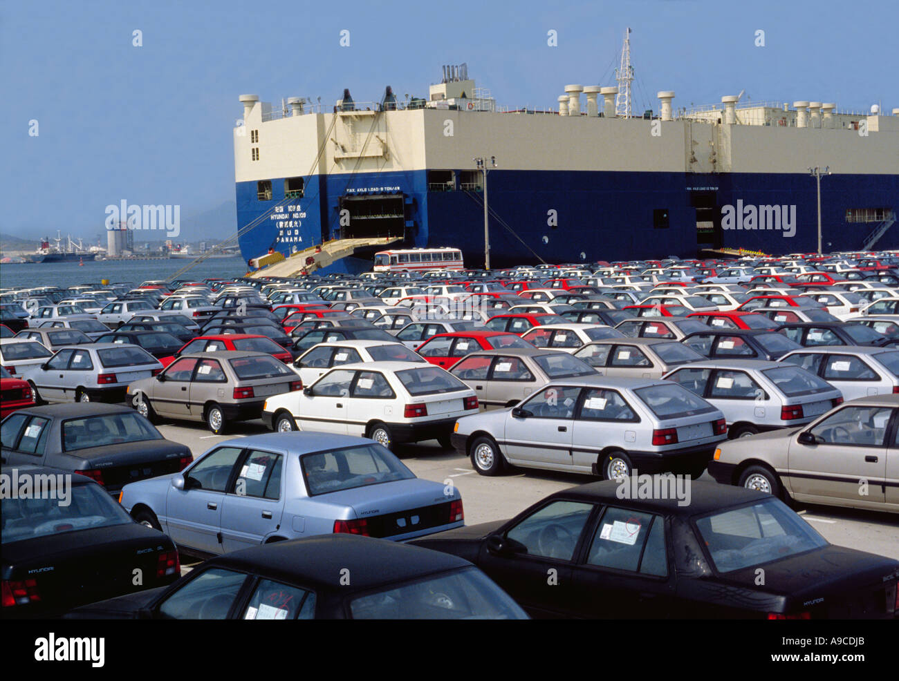 Cars and autos are waiting to be loaded into the container ship for ...