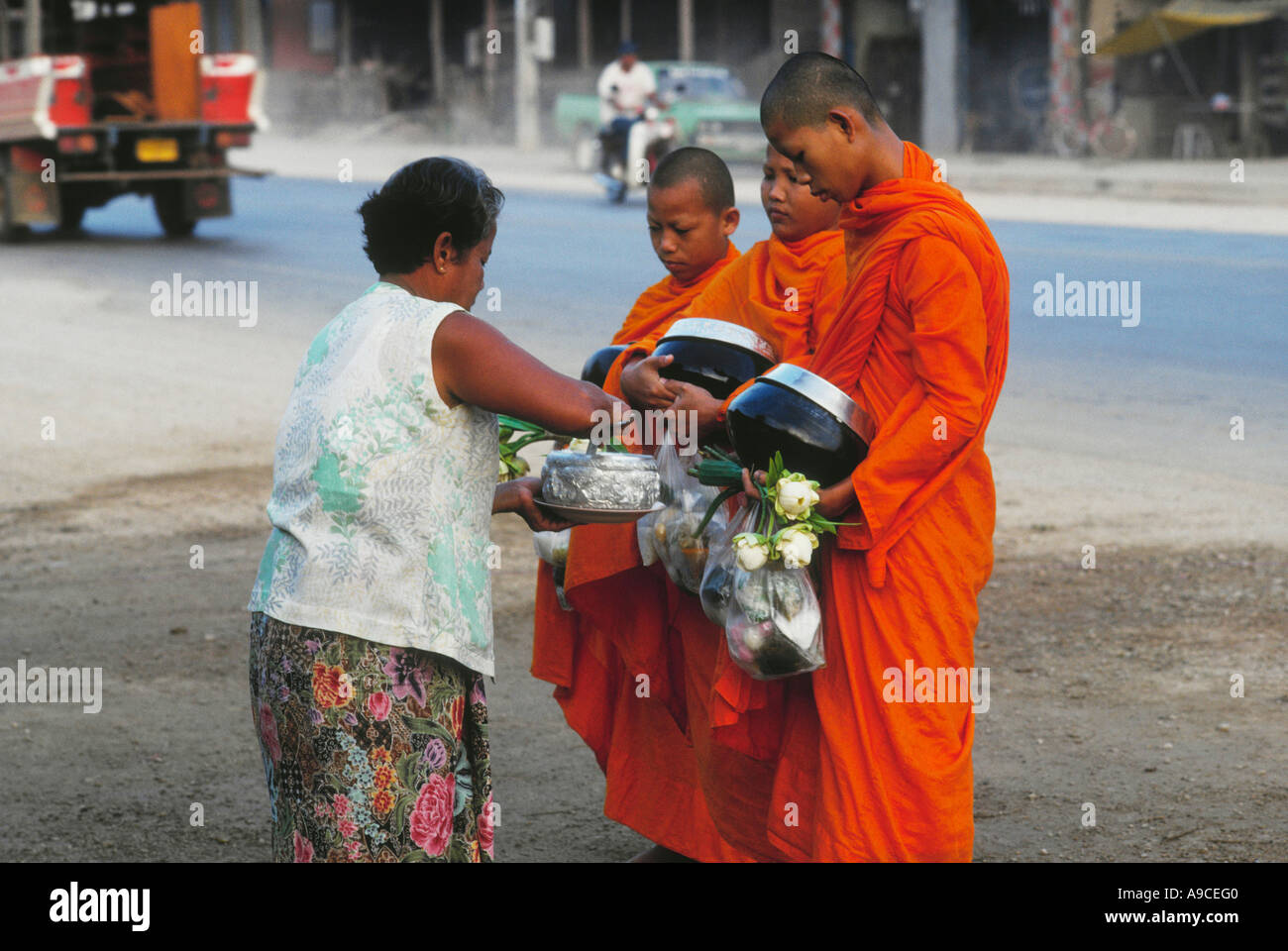 Woman giving food to Monk Stock Photo - Alamy