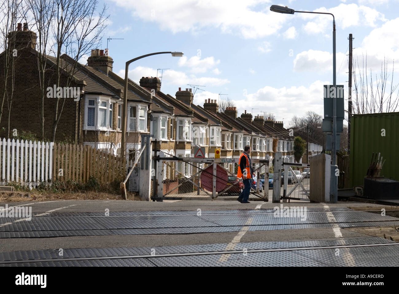 Gatekeeper closing manned railroad level crossing Stock Photo - Alamy