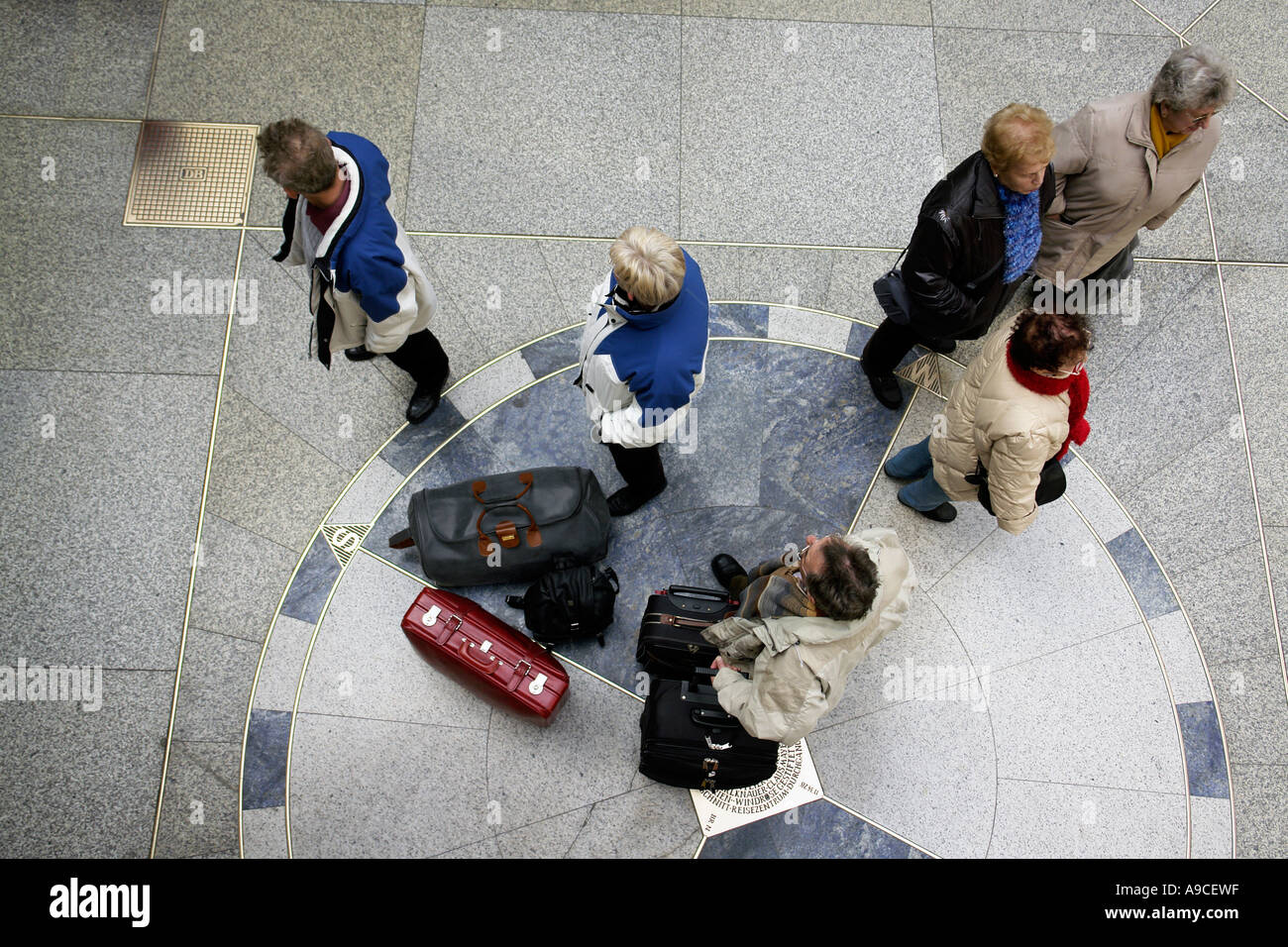 travellers at train station waiting check in Stock Photo - Alamy