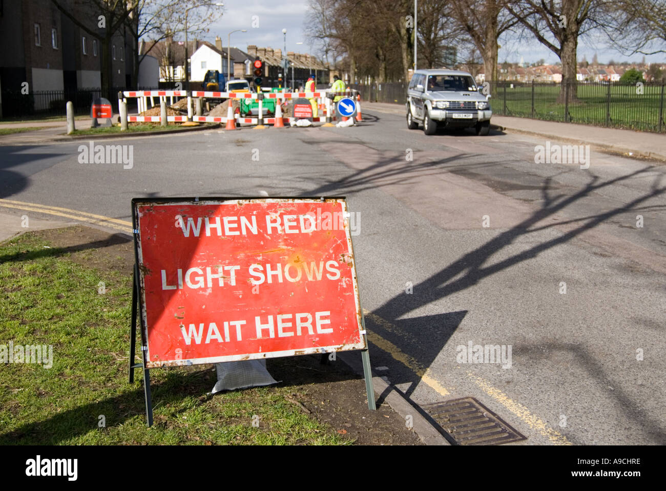 Wait here when red light shows road sign Stock Photo - Alamy