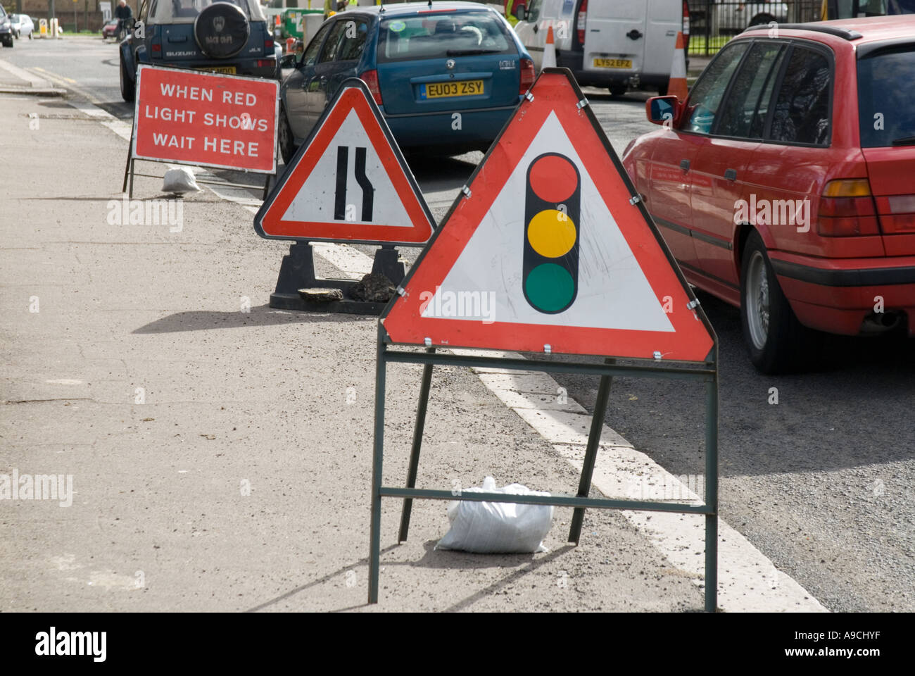 Wait here when red light shows road sign Stock Photo - Alamy