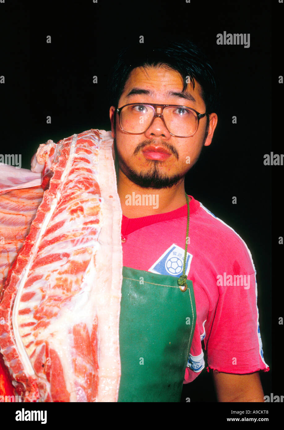 A chinese butcher carrying half pig on his shoulder Hong Kong china ...