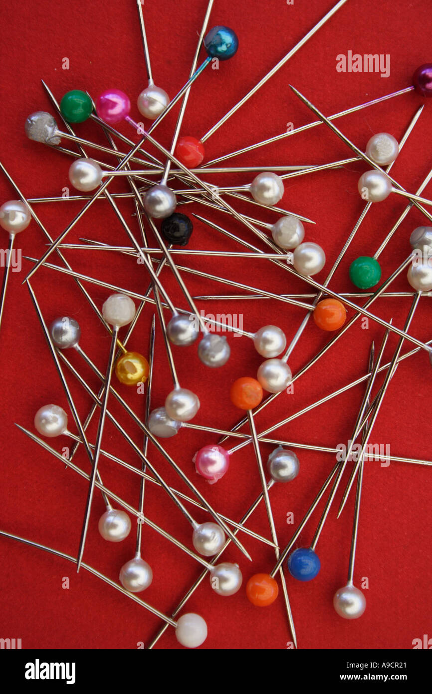 A PILE OF COLOURED PINS ON A RED BACKGROUND BAPD1491 Stock Photo - Alamy