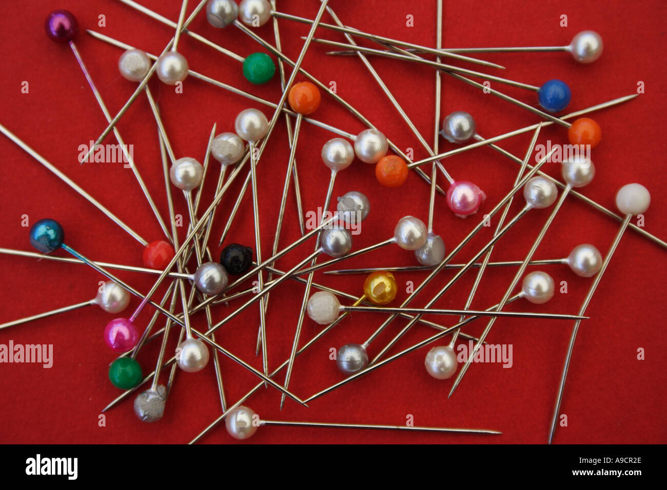 A PILE OF COLOURED PINS ON A RED BACKGROUND BAPD1495 Stock Photo - Alamy