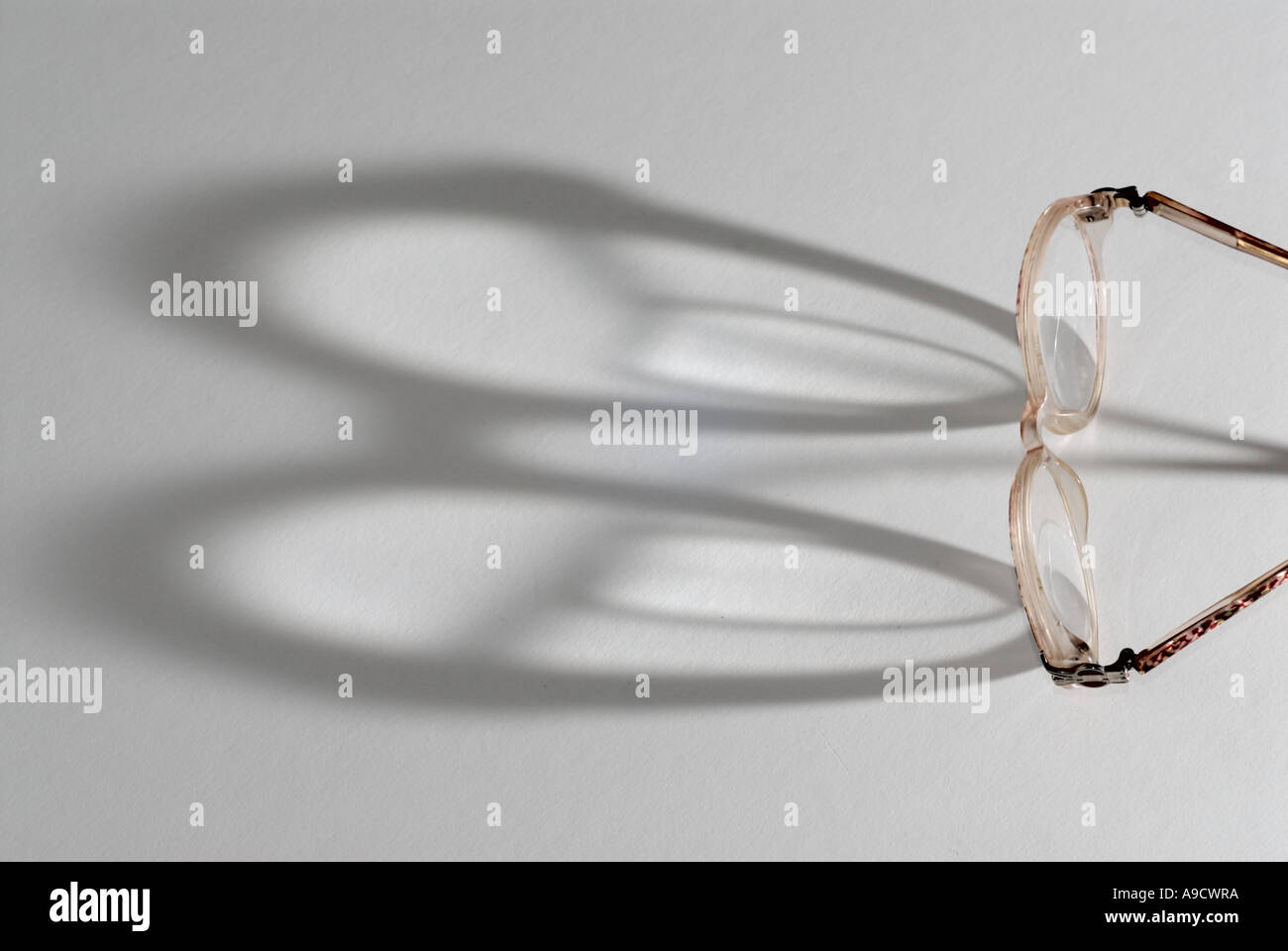 Long shadow cast by spectacles by low sun on white background Stock ...