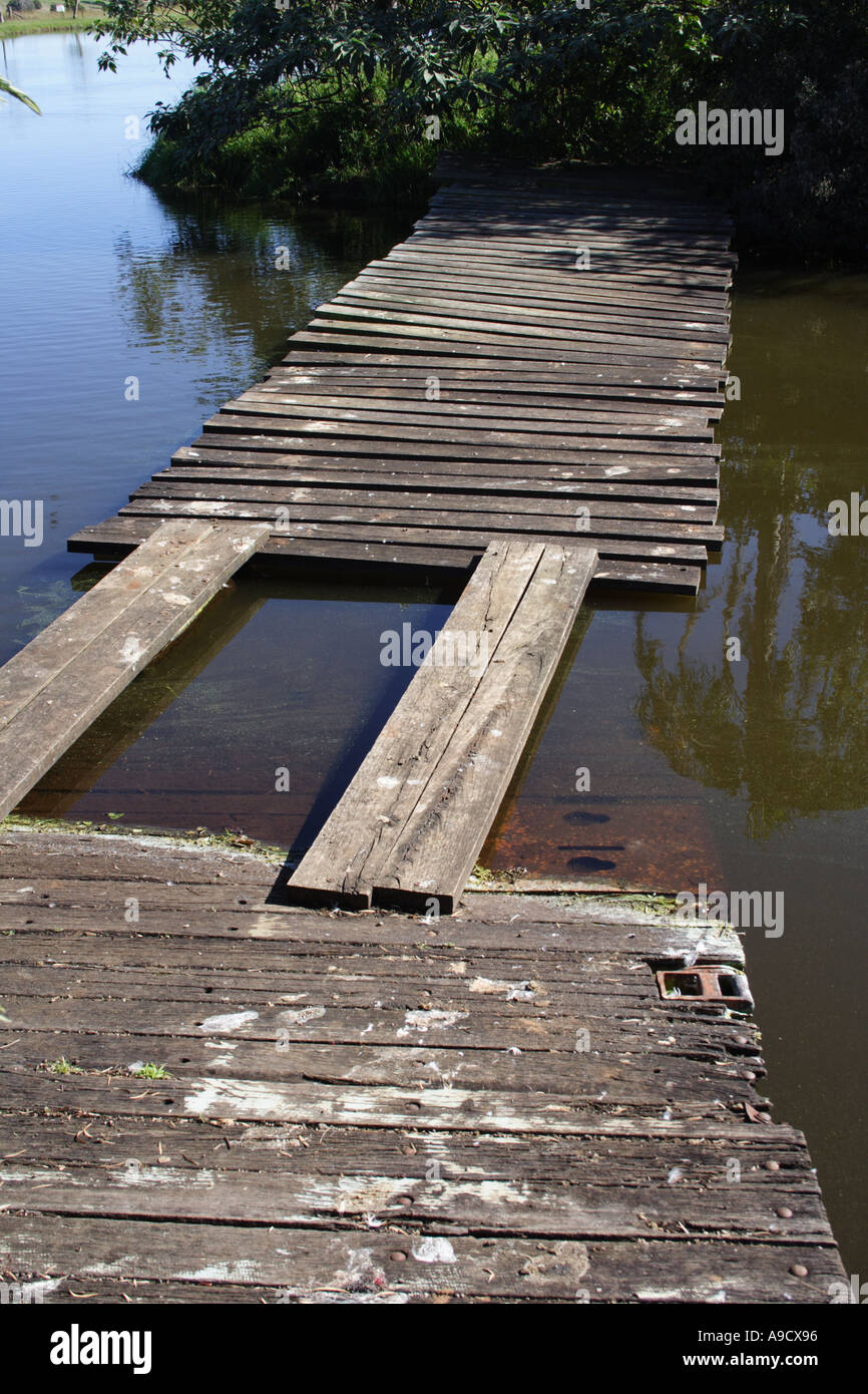 A RUN DOWN BRIDGE ACROSS A RIVER BAPD1560 Stock Photo - Alamy