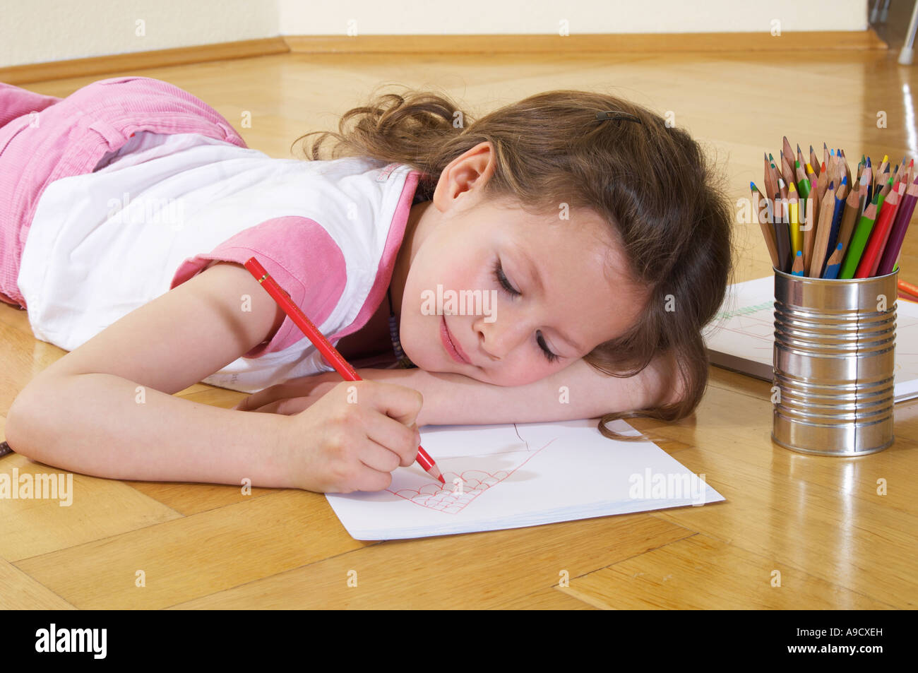 young girl lying on floor drawing Stock Photo - Alamy