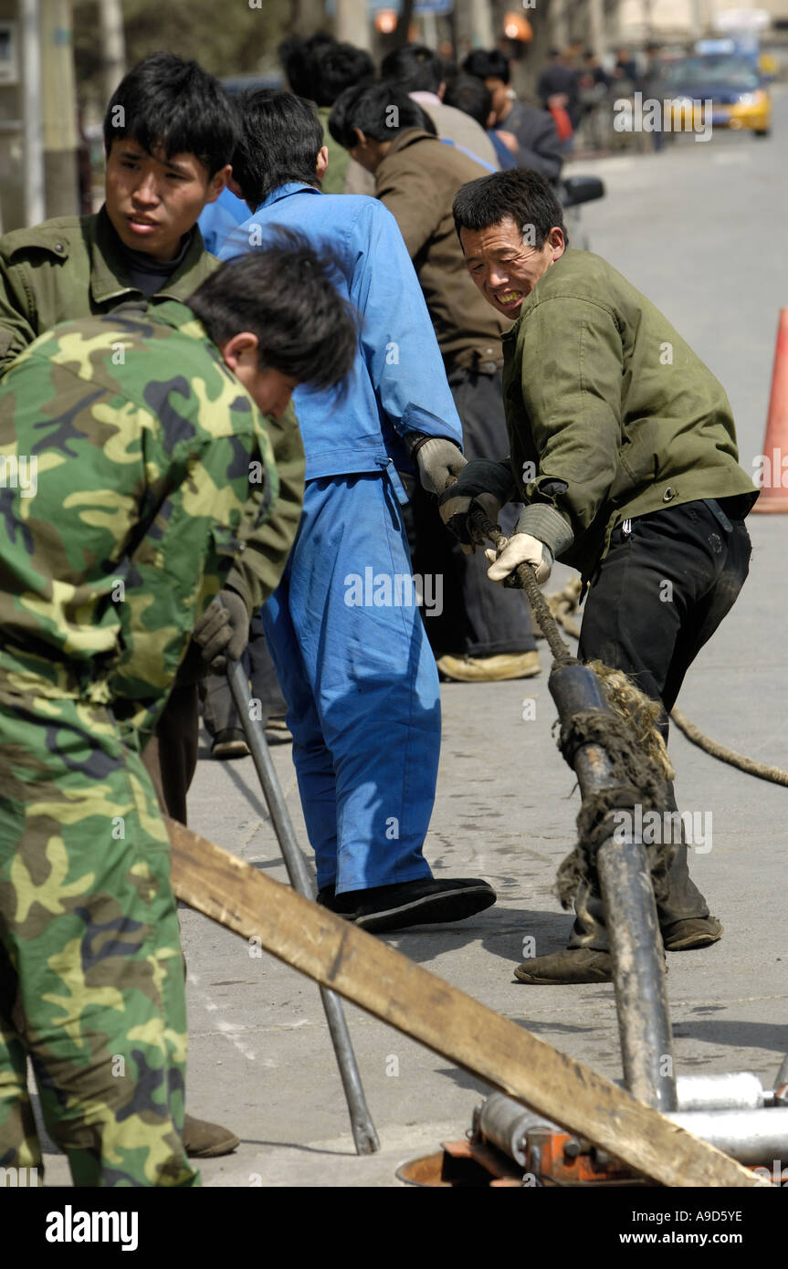 Chinese workers replace electric cables on a street in Beijing China 19 ...