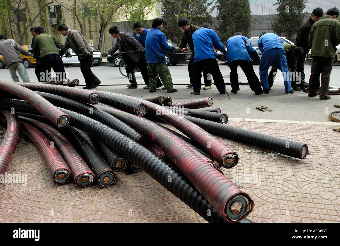 Chinese workers replace electric cables on a street in Beijing China 19 ...
