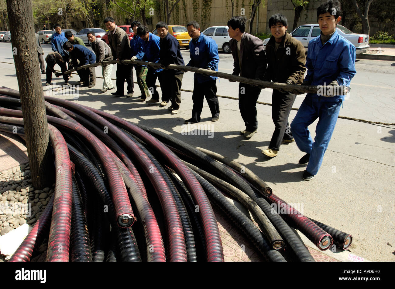 Chinese workers replace electric cables on a street in Beijing China 19 ...
