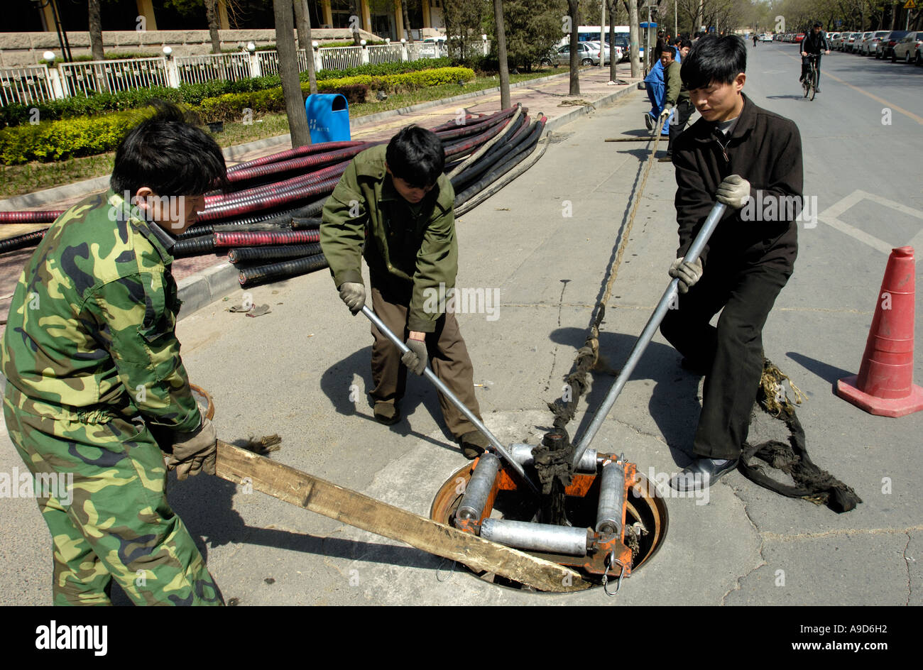 Chinese workers replace electric cables on a street in Beijing China 19 ...