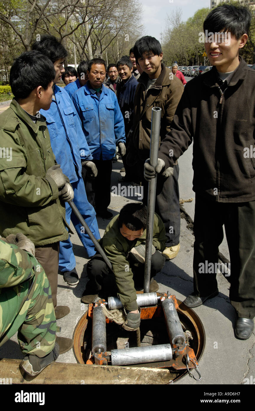 Chinese workers replace electric cables on a street in Beijing China 19 ...