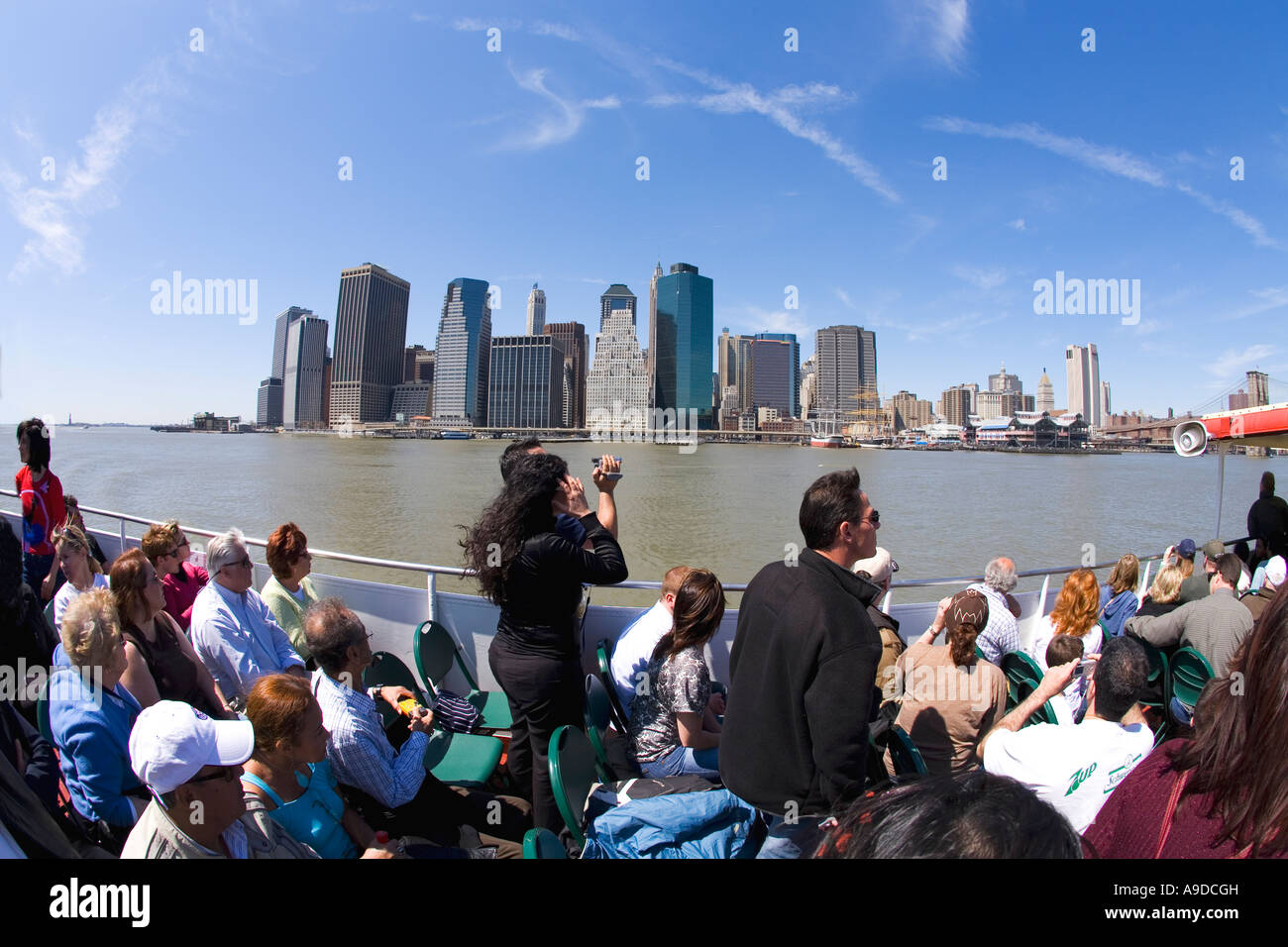 Tourists admire the view of Lower Manhattan in spring sun sunshine and ...
