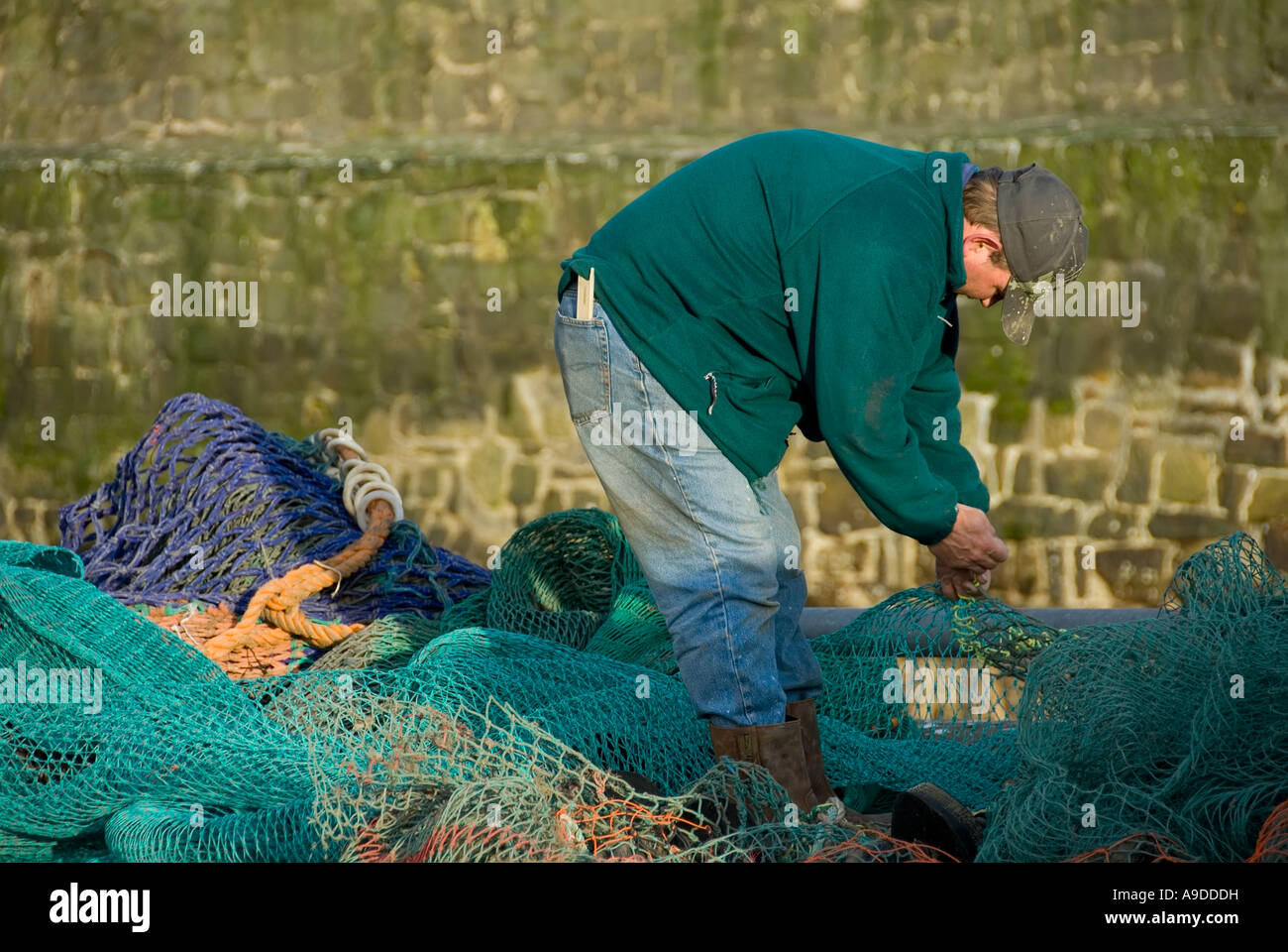 Fisherman undoing the knots of the fishing nets Stock Photo - Alamy