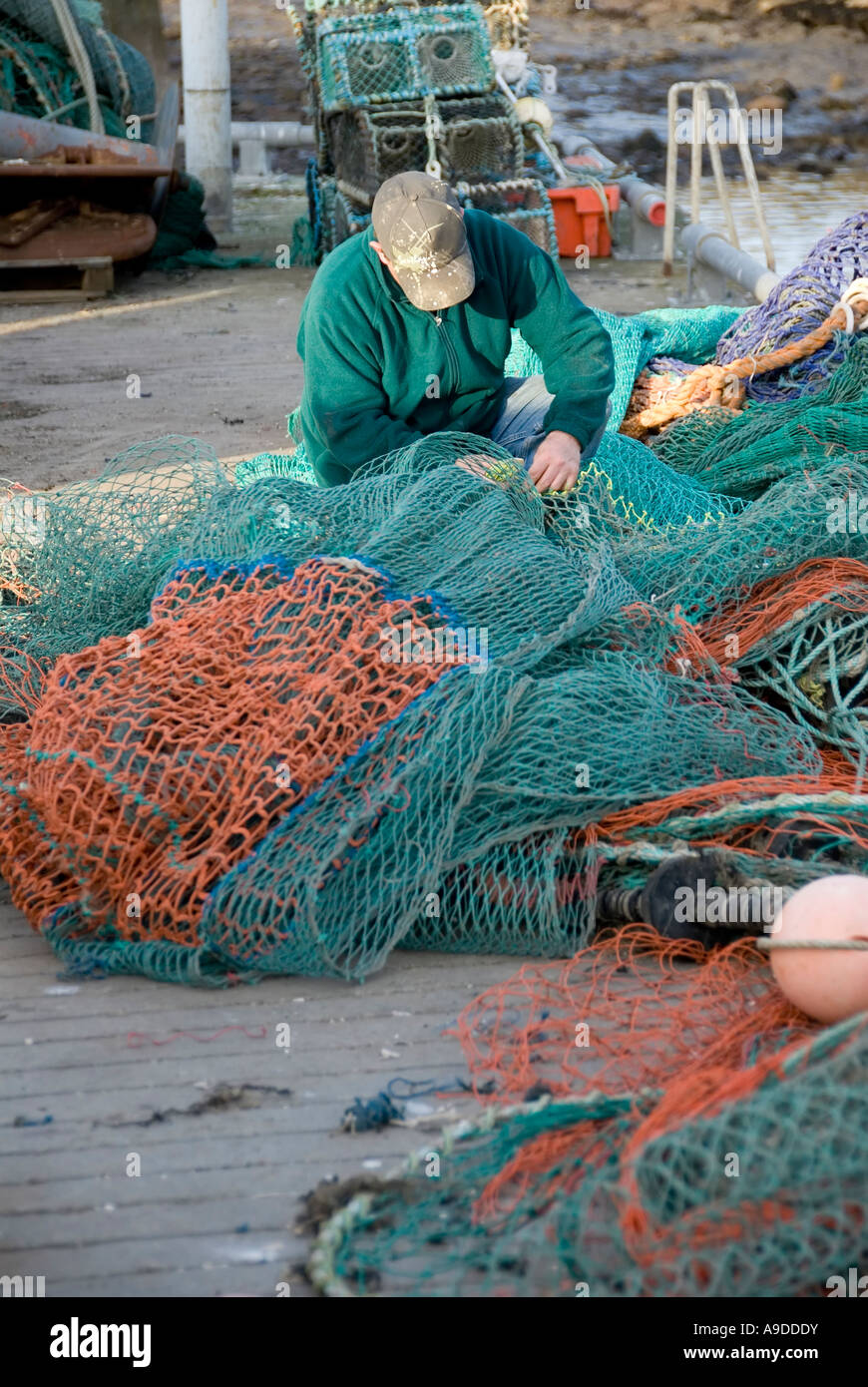 Fisherman undoing the knots of the fishing nets Stock Photo - Alamy