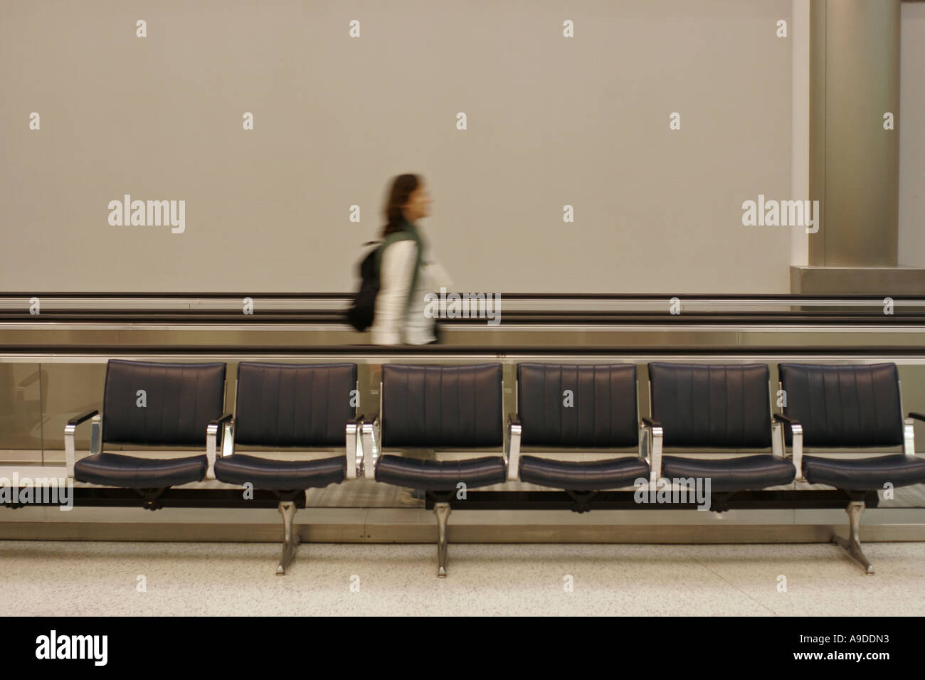Woman walking on the moving walkway Stock Photo - Alamy