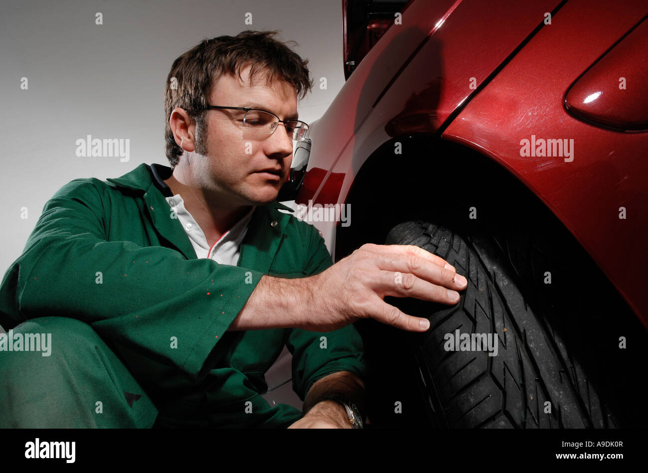 Car Mechanic checking tyres man transport Stock Photo - Alamy
