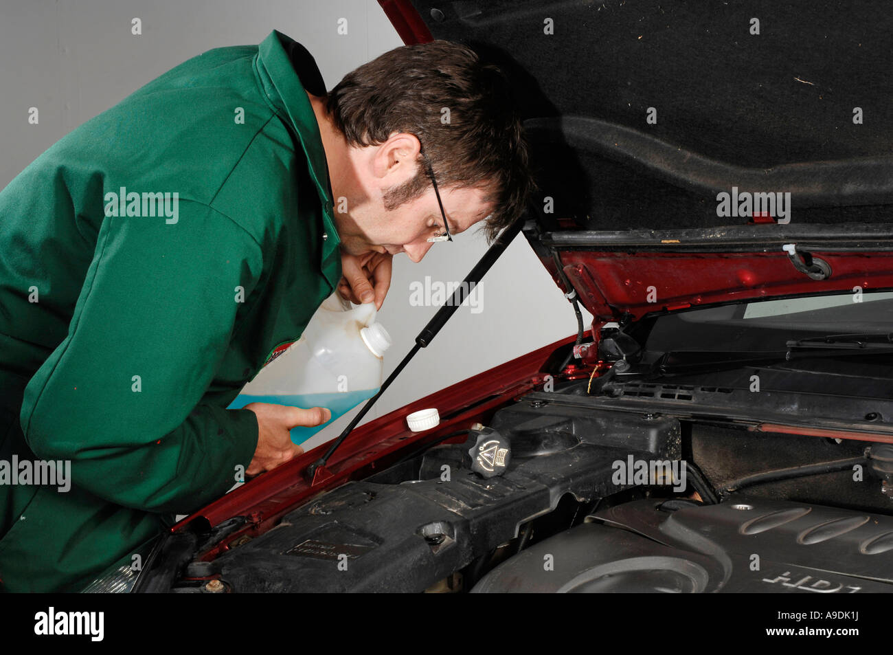 Mechanic topping up fluid Stock Photo - Alamy
