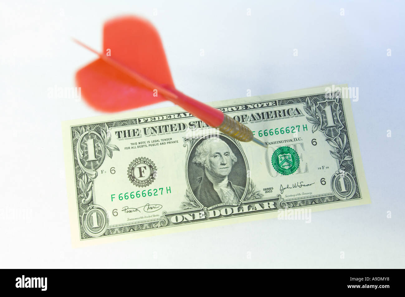 dart thrown at one dollar bill US Stock Photo - Alamy