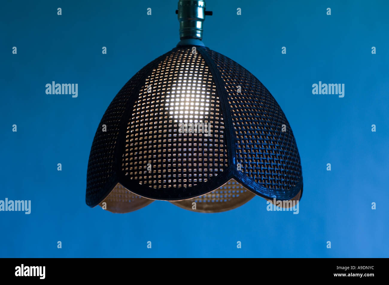 illuminated lamp hanging from ceiling with perforated lamp shade Stock ...