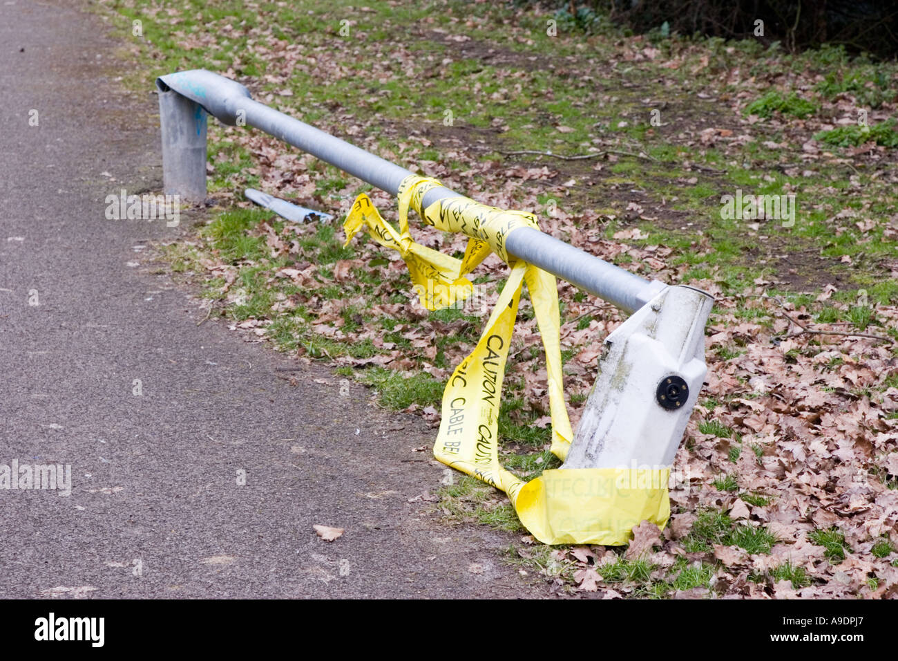 Metal street light bent over to the ground by mindless vandals Stock ...