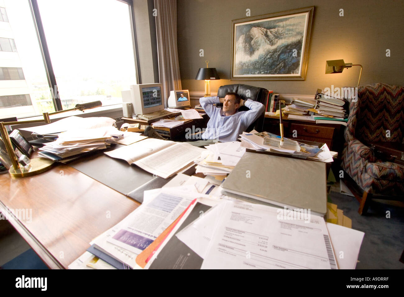 businessman sitting at office desk staring at ceiling Stock Photo - Alamy