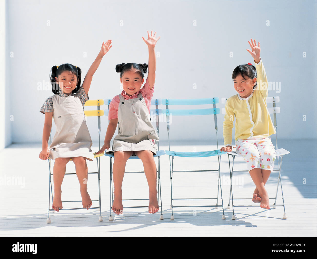 Girl sitting on chairs Stock Photo - Alamy