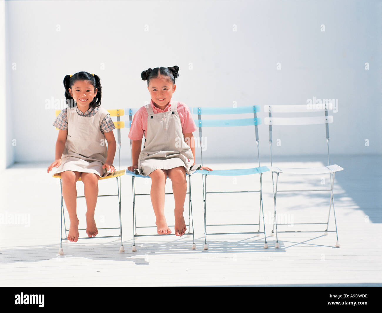 Girl sitting on chairs Stock Photo - Alamy