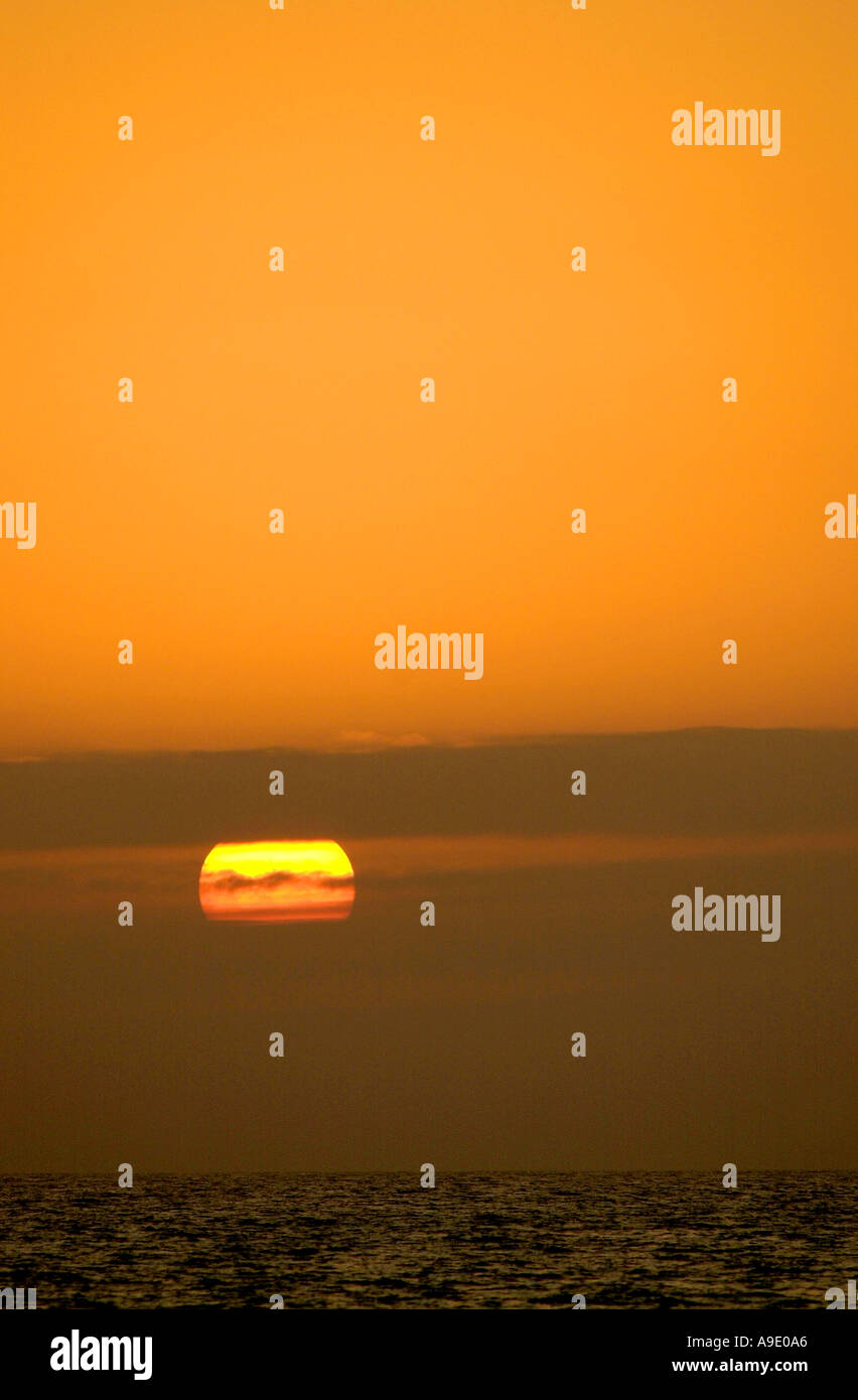 Vertical color image of sun setting over ocean Stock Photo - Alamy