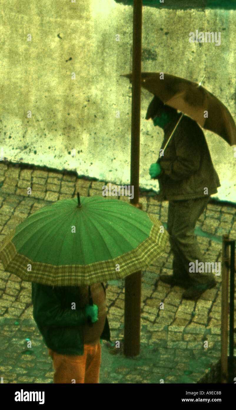 Men in rain with umbrellas Stock Photo - Alamy
