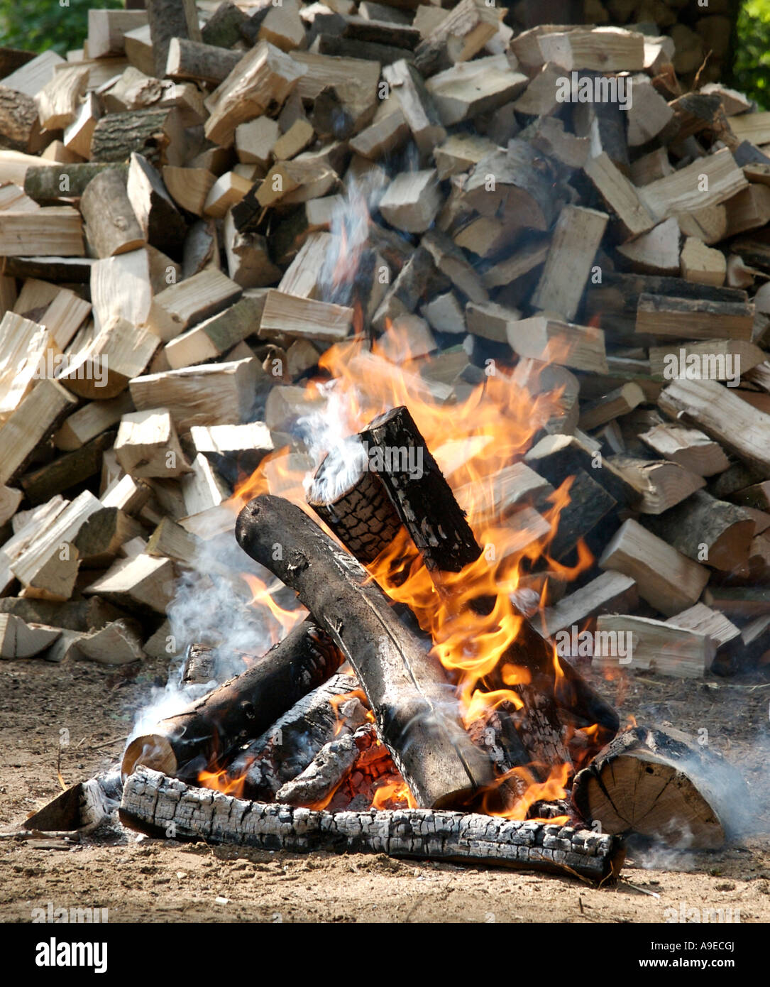 A fire in front of a heap of wood Stock Photo - Alamy